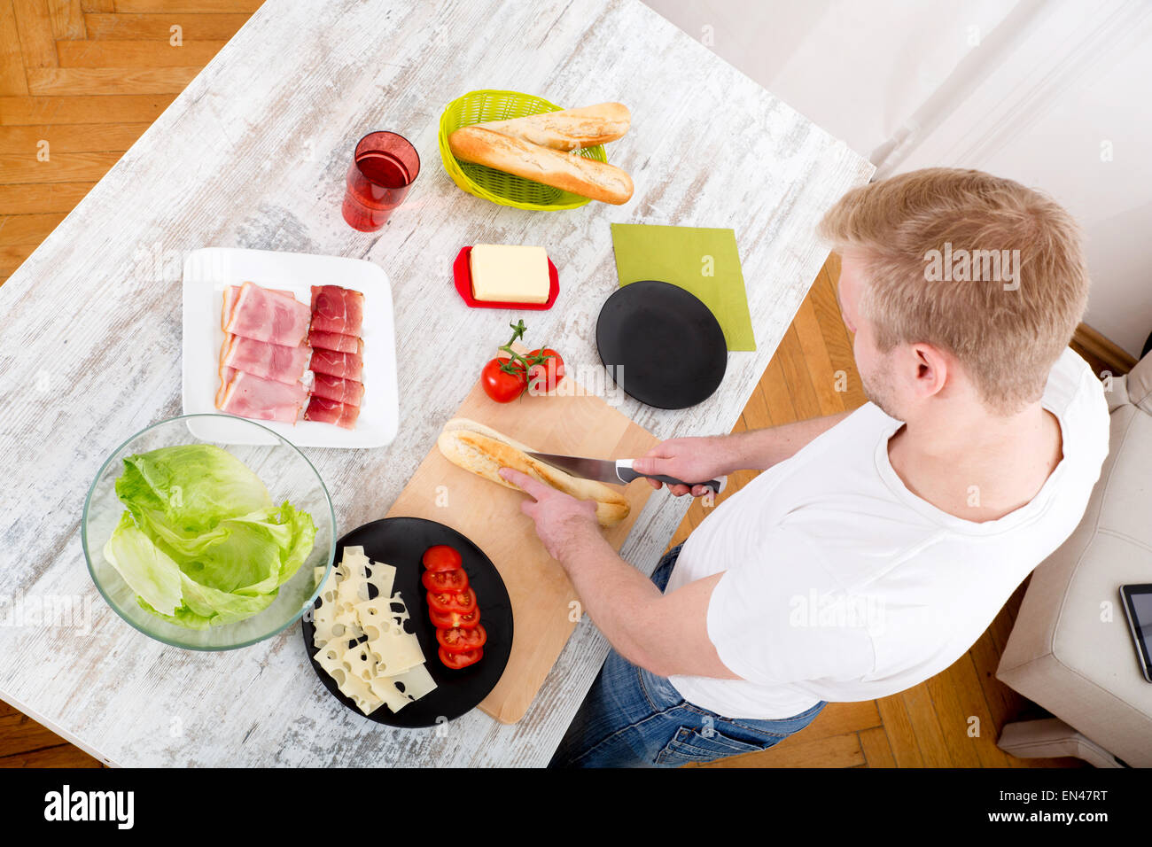A young man preparing a sandwich in the kitchen Stock Photo - Alamy