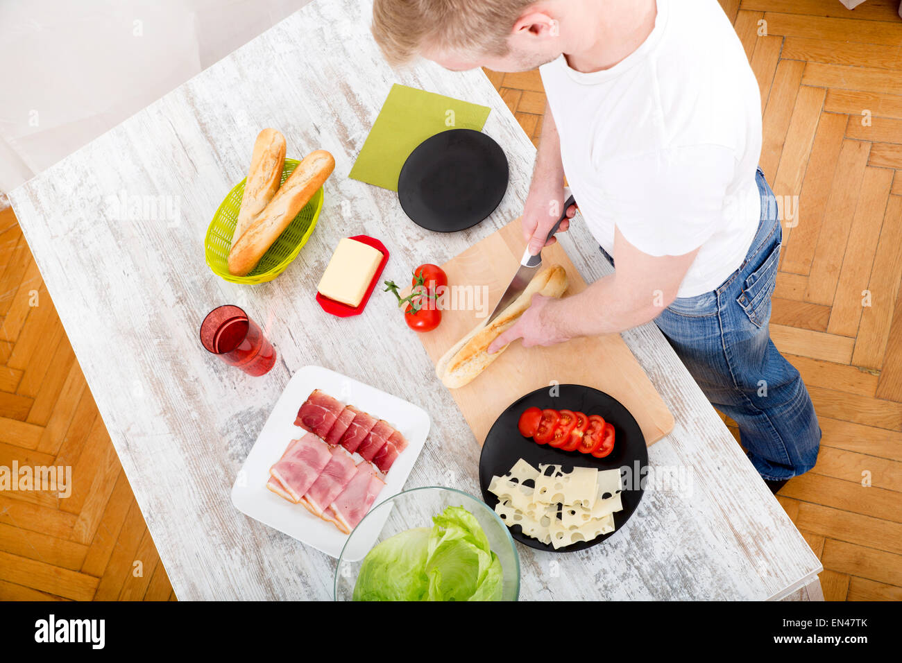 A young man preparing a sandwich in the kitchen Stock Photo - Alamy