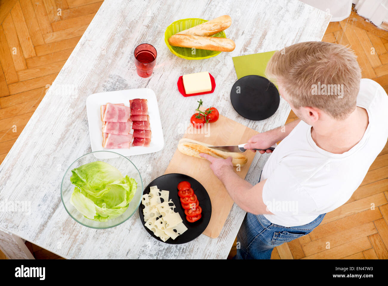 A young man preparing a sandwich in the kitchen Stock Photo - Alamy