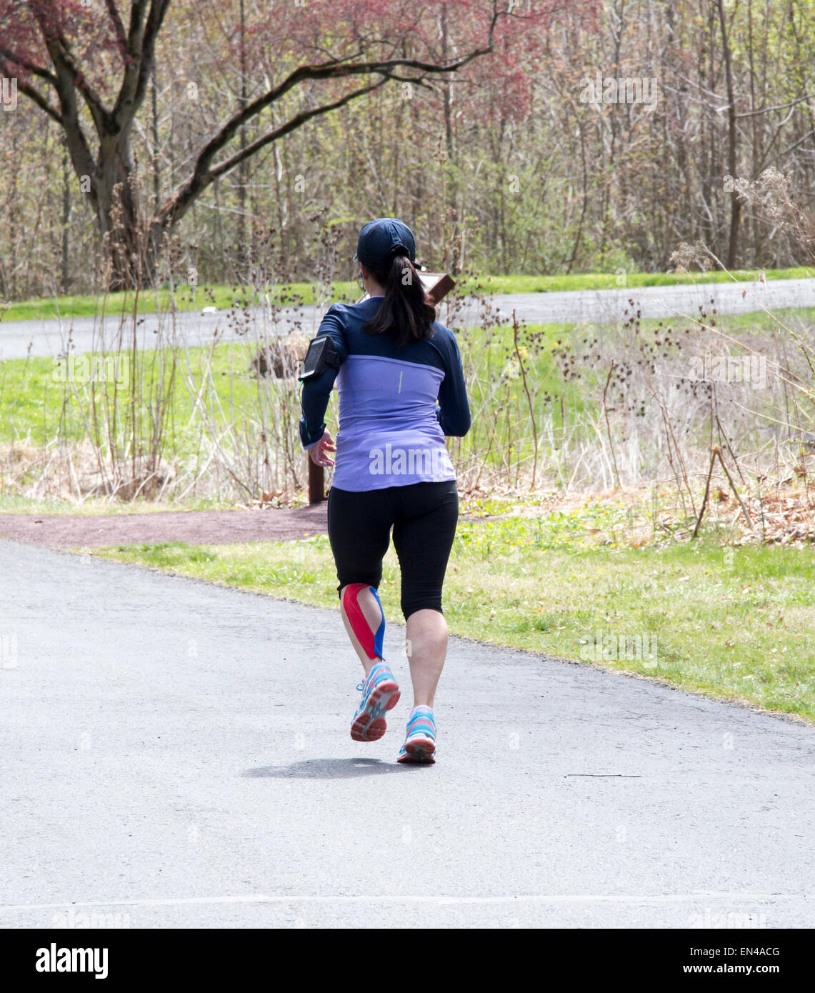 Woman girl lady running in the park on a paved path Stock Photo - Alamy