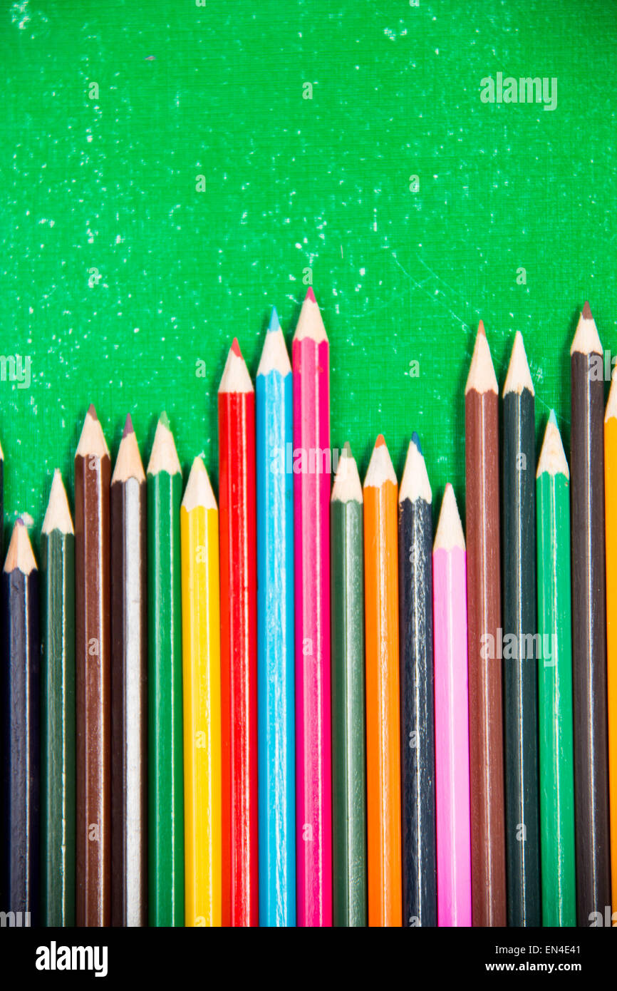 Colorful vertical pencil crayon border on green Stock Photo - Alamy