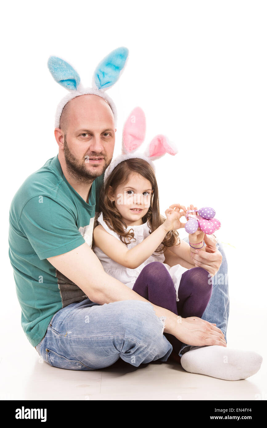 Cheerful father and daughter with bunny ears holding Easter eggs Stock ...