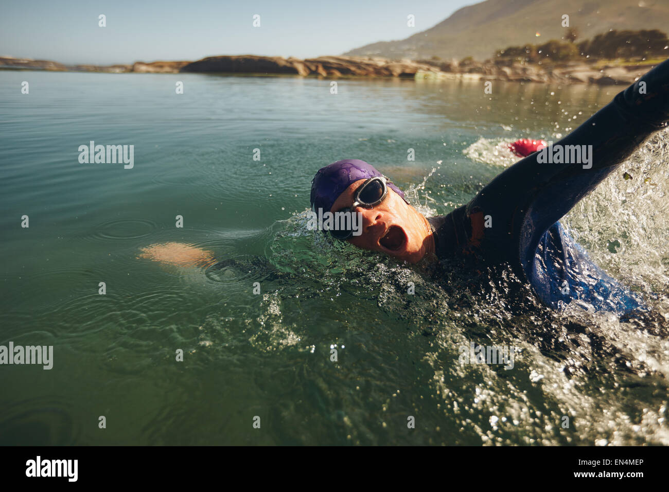 Open water swimming. Male athlete swimming in lake. Triathlon long ...