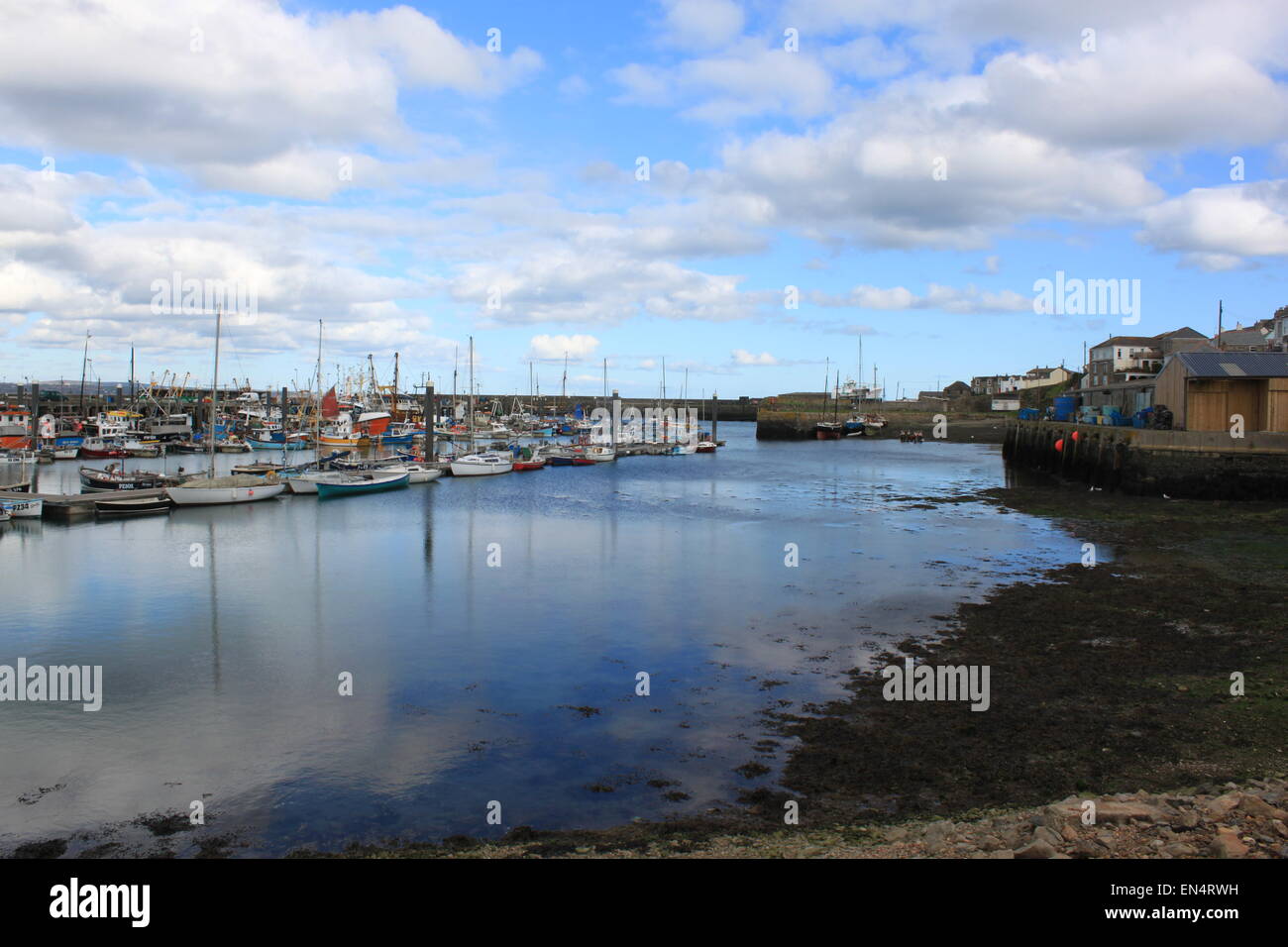 newlyn harbour with sailing and fishing boats on a calm sunny day in ...