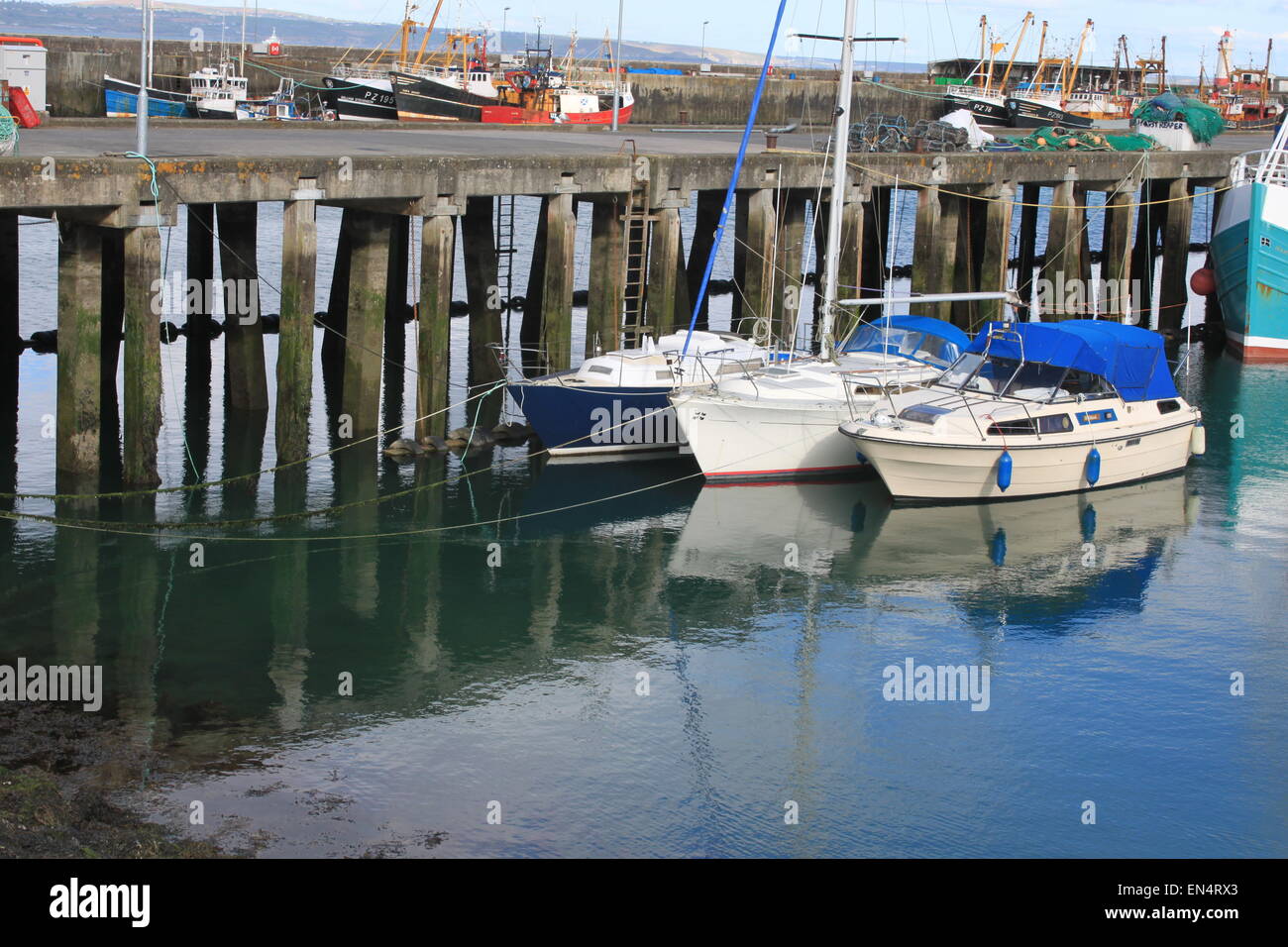 newlyn harbour with sailing and fishing boats on a calm sunny day in ...