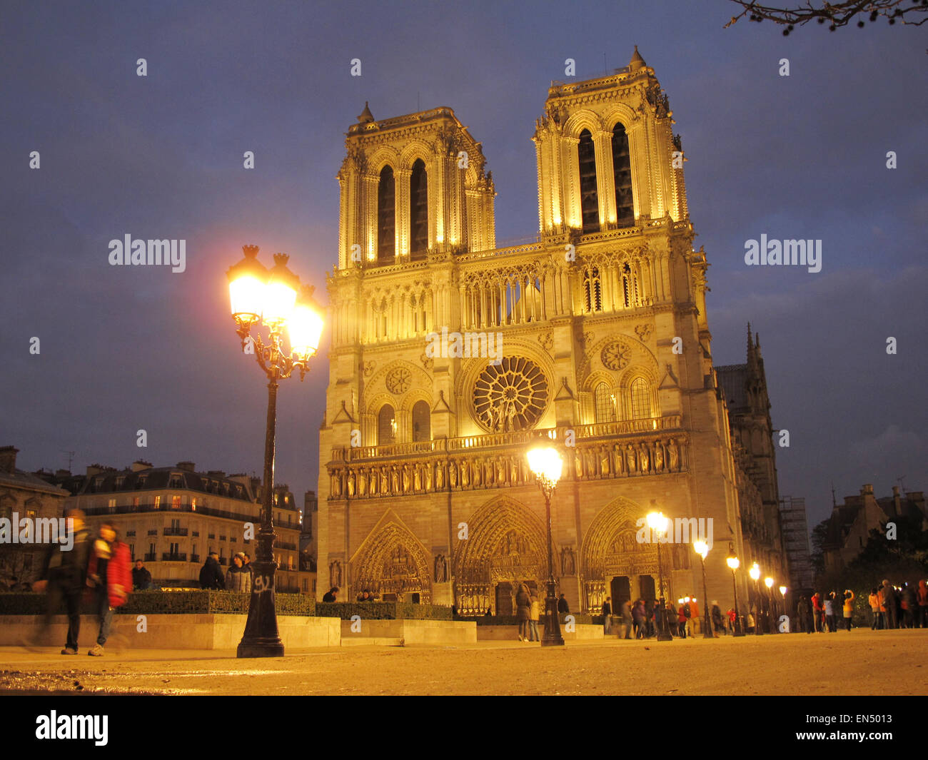 The famous cathedral of Notre-Dame shines illuminated at dusk on the ...