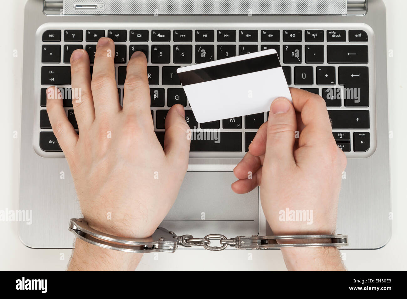 credit card cheater with handcuff on laptop Stock Photo - Alamy
