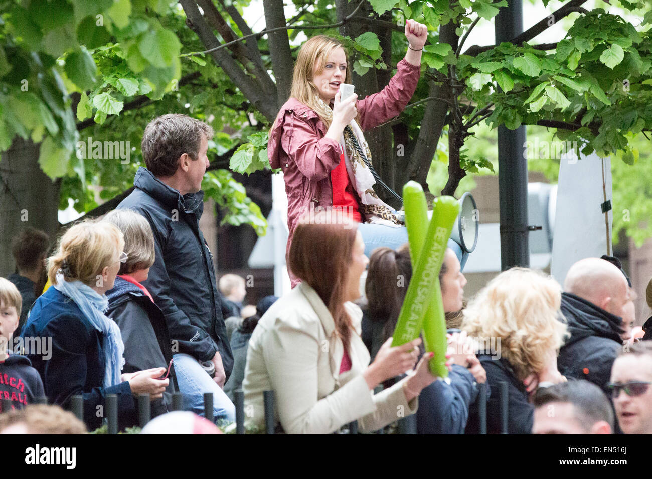 Young woman using a megaphone to cheer on the runners at the 2015 ...