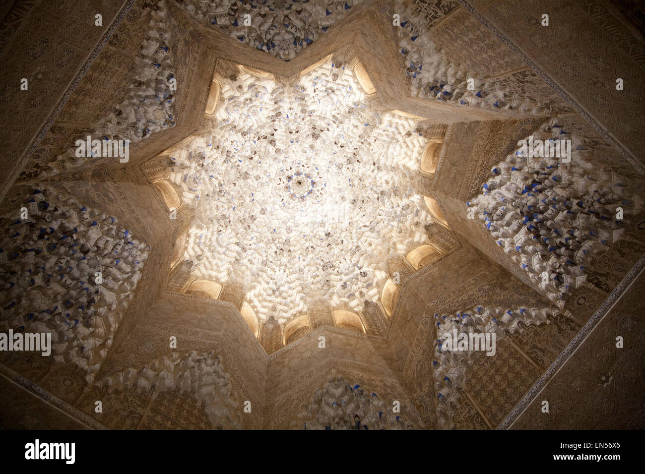 Illuminated view at night of richly decorated Islamic stonework ceiling ...