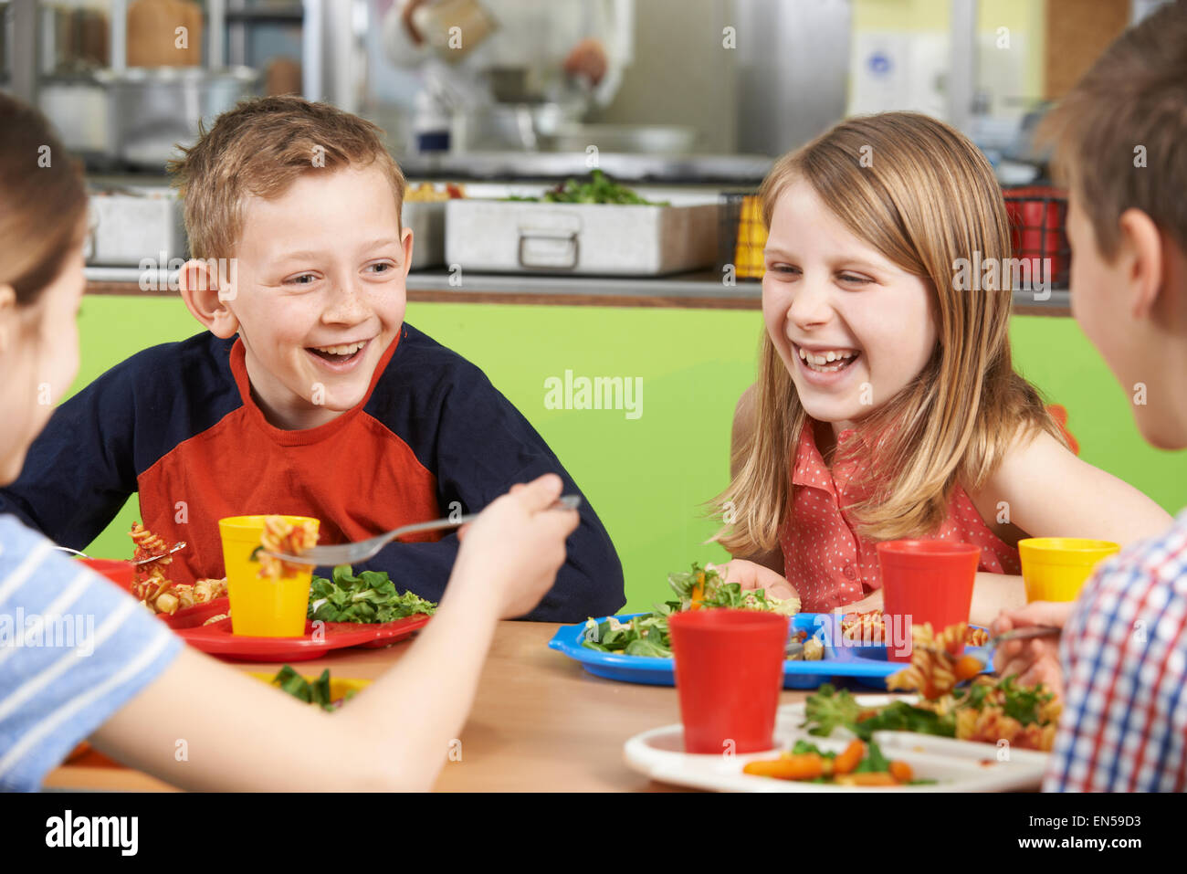 Group Of Pupils Sitting At Table In School Cafeteria Eating Meal Stock ...