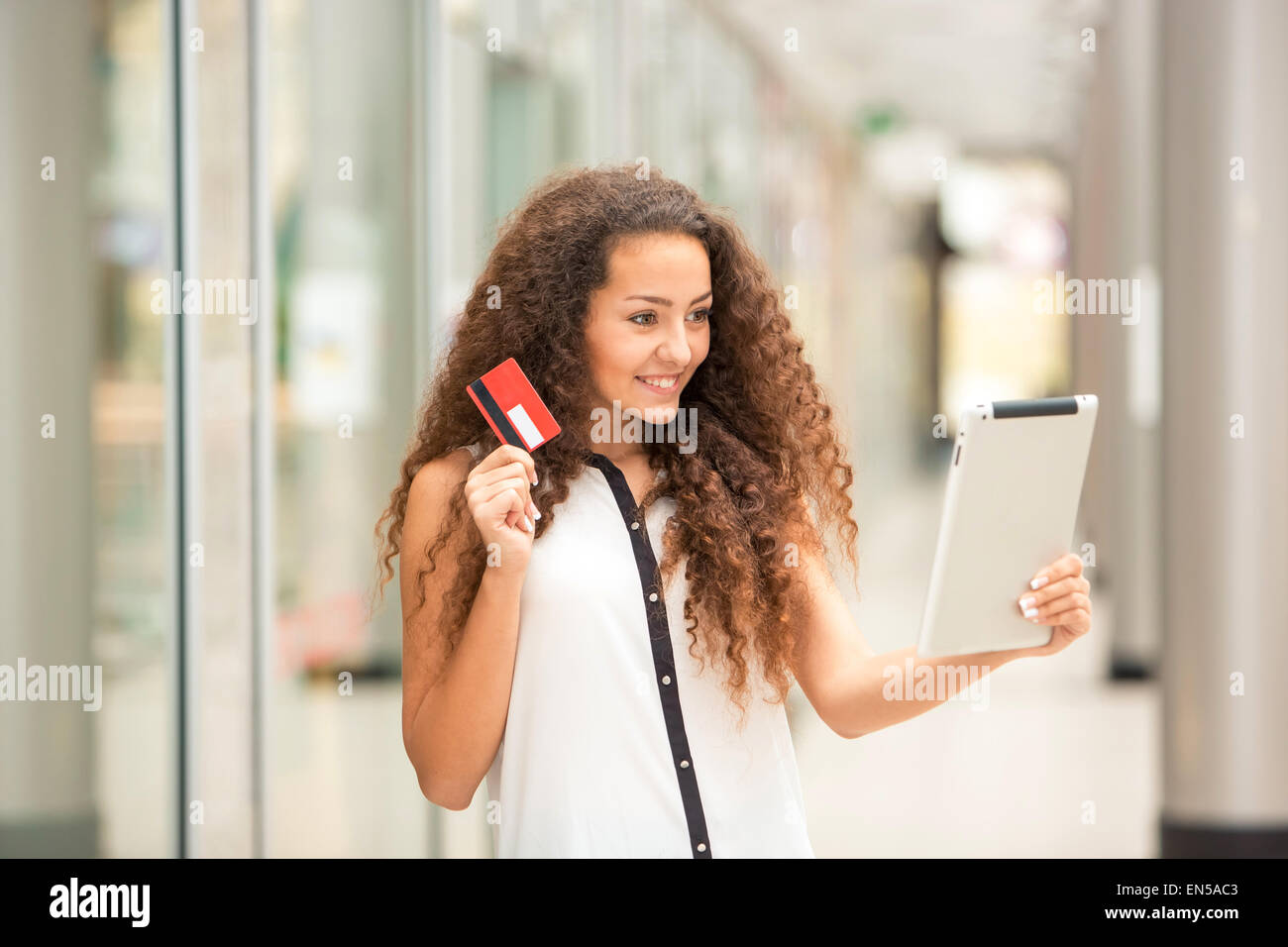 Beautiful young girl paying by credit card for shopping Stock Photo - Alamy