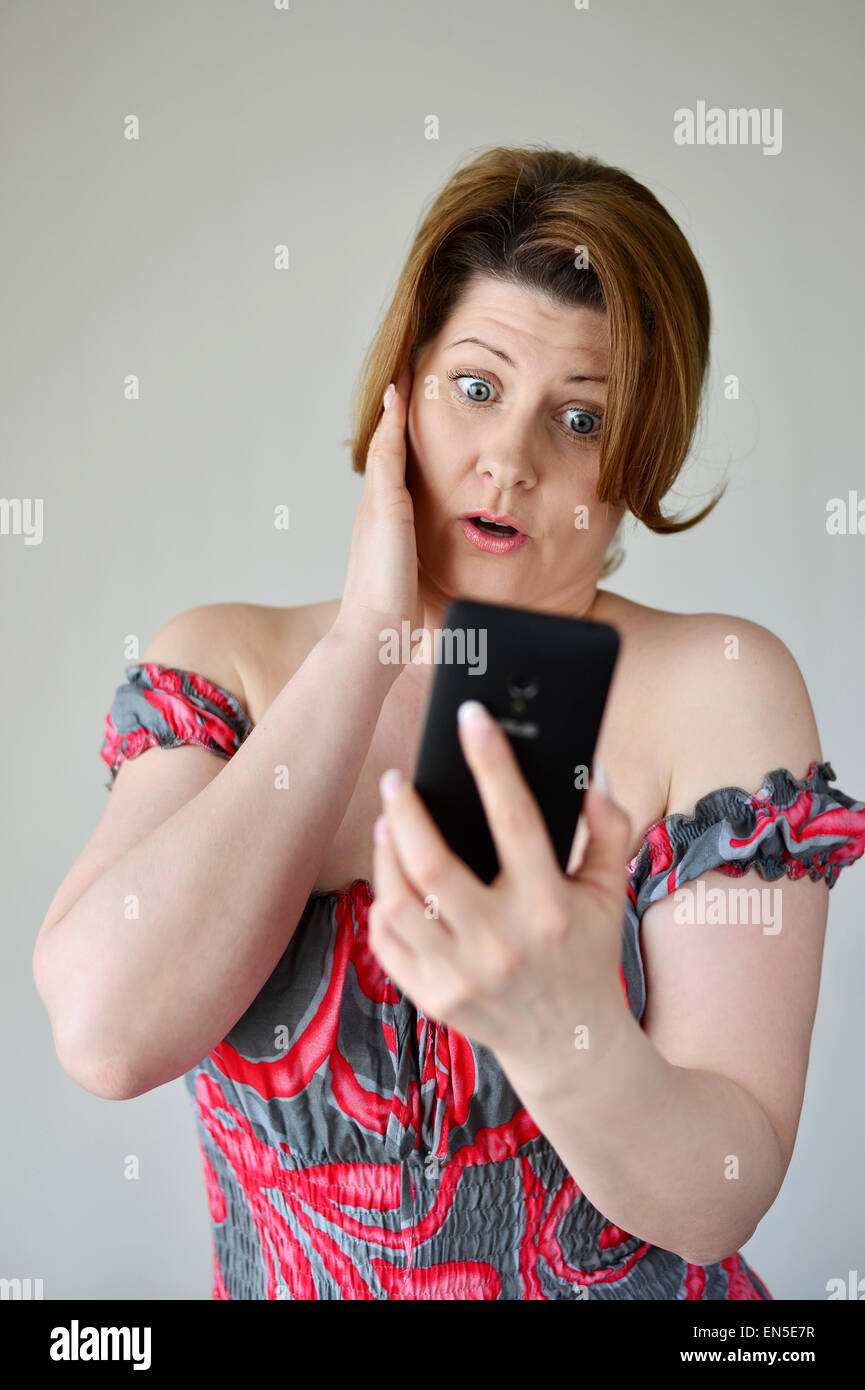 Shocked young woman reading the text message Stock Photo - Alamy