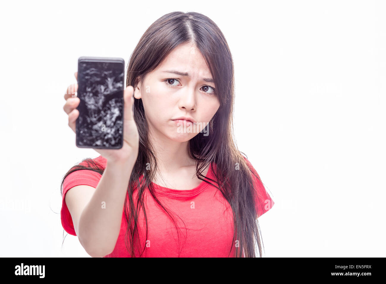 Frowning Chinese woman holding cell phone with cracked screen Stock ...