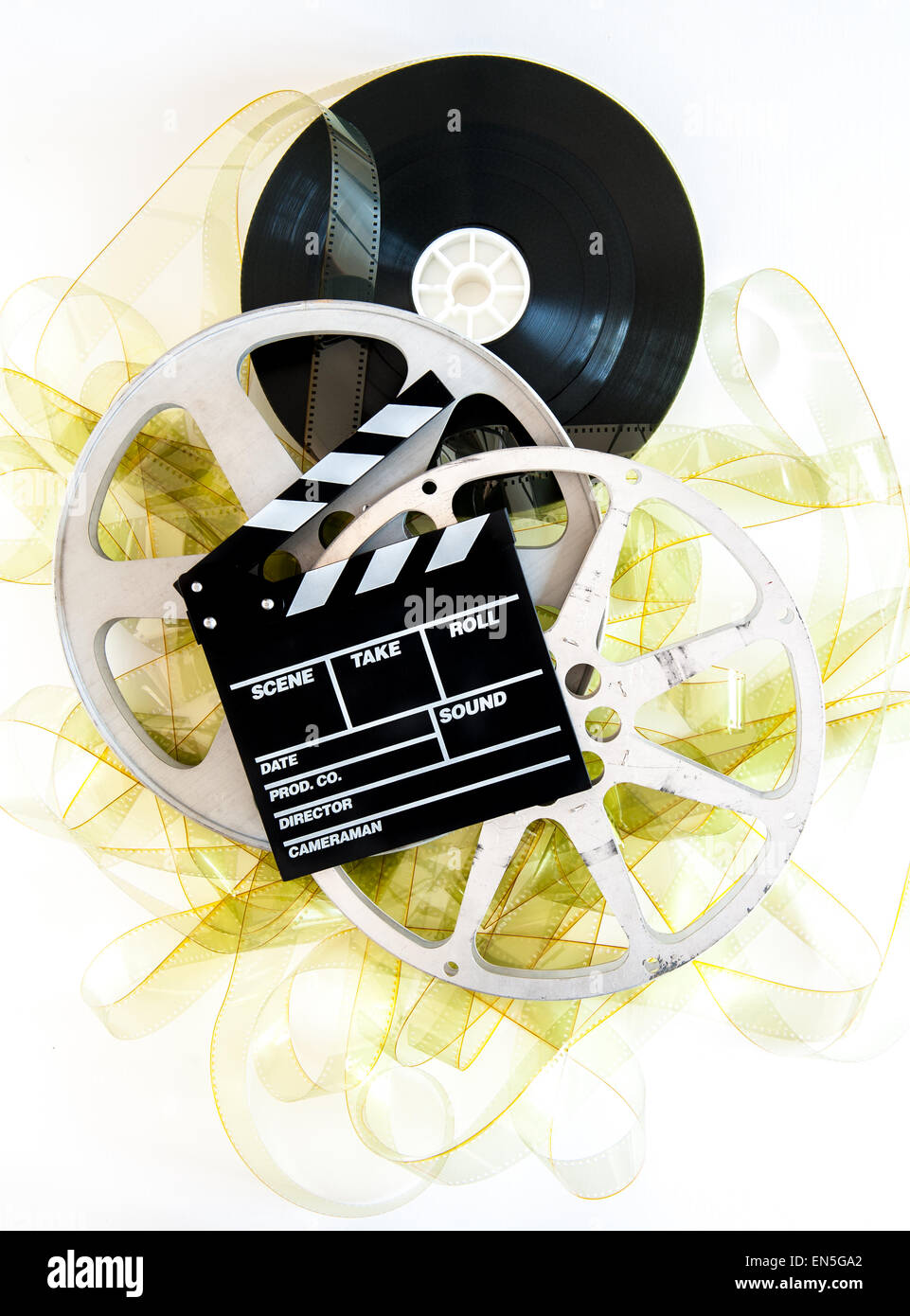 Movie clapper on 35mm yellow unrolled film and cinema reels on neutral ...