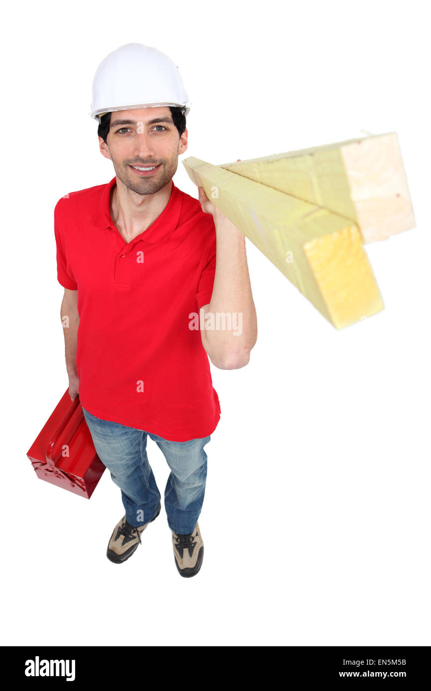 Man with toolbox and planks of wood on his shoulder Stock Photo - Alamy