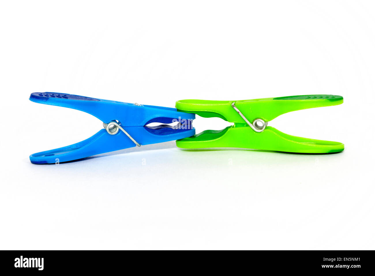 Green clothespin clamping blue clothespin on a white background Stock ...