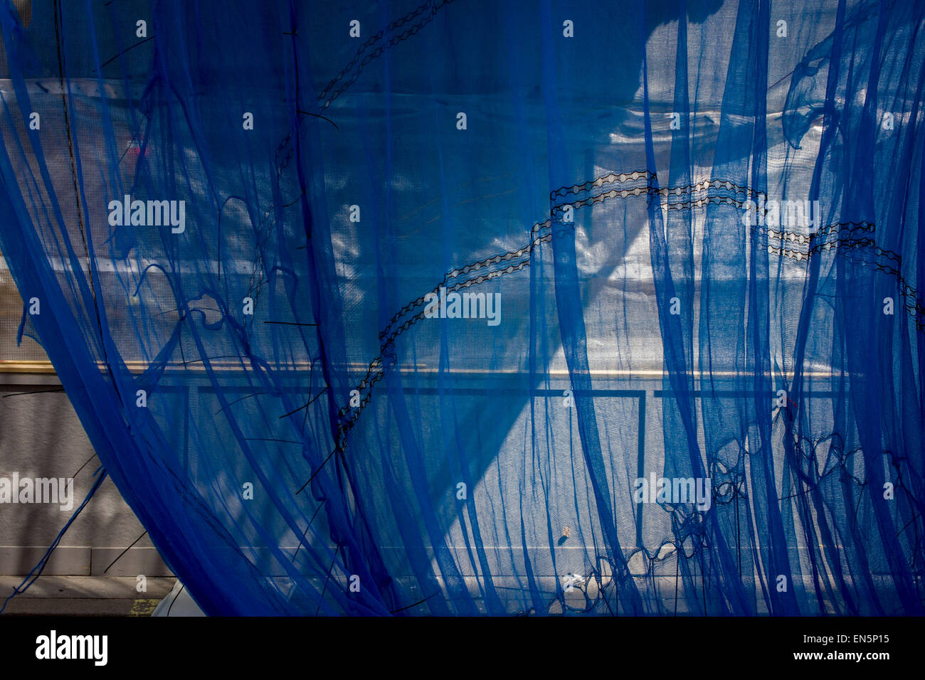Blue safety netting from a Westminster construction site, blows in the ...