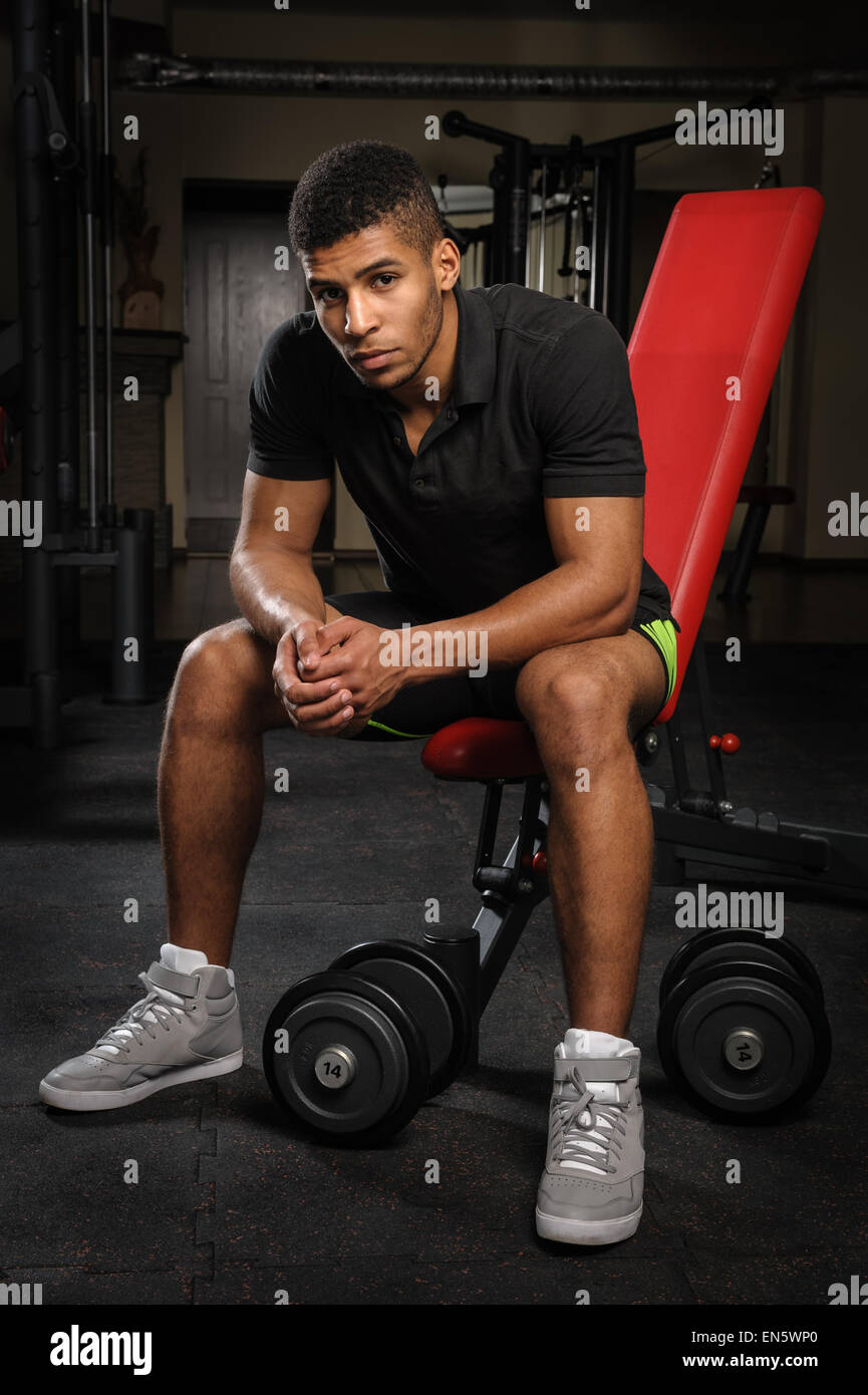 young man sitting on bench at gym Stock Photo - Alamy