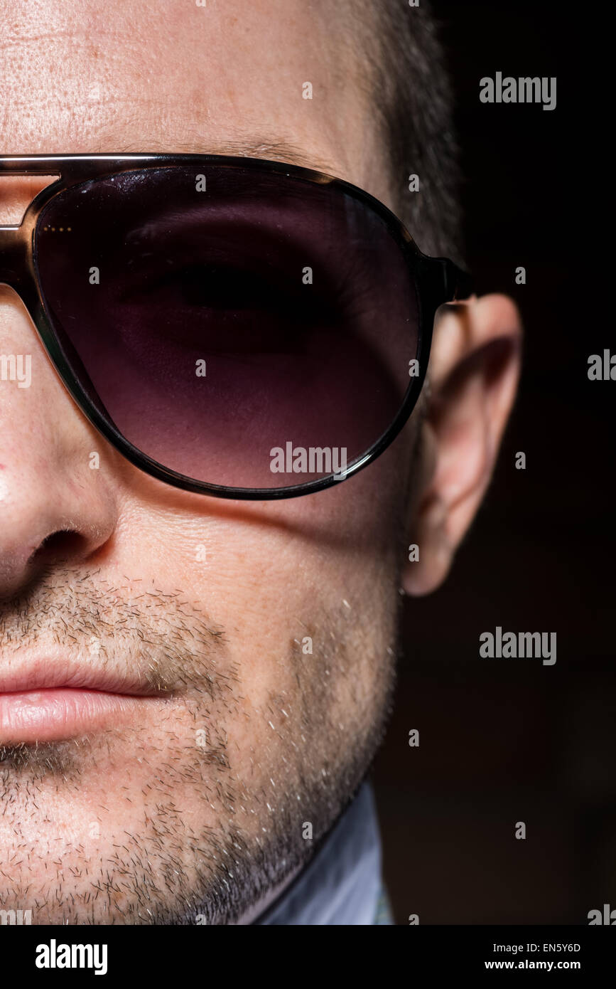 Tight portrait of a confident man with high contrast lighting wearing ...