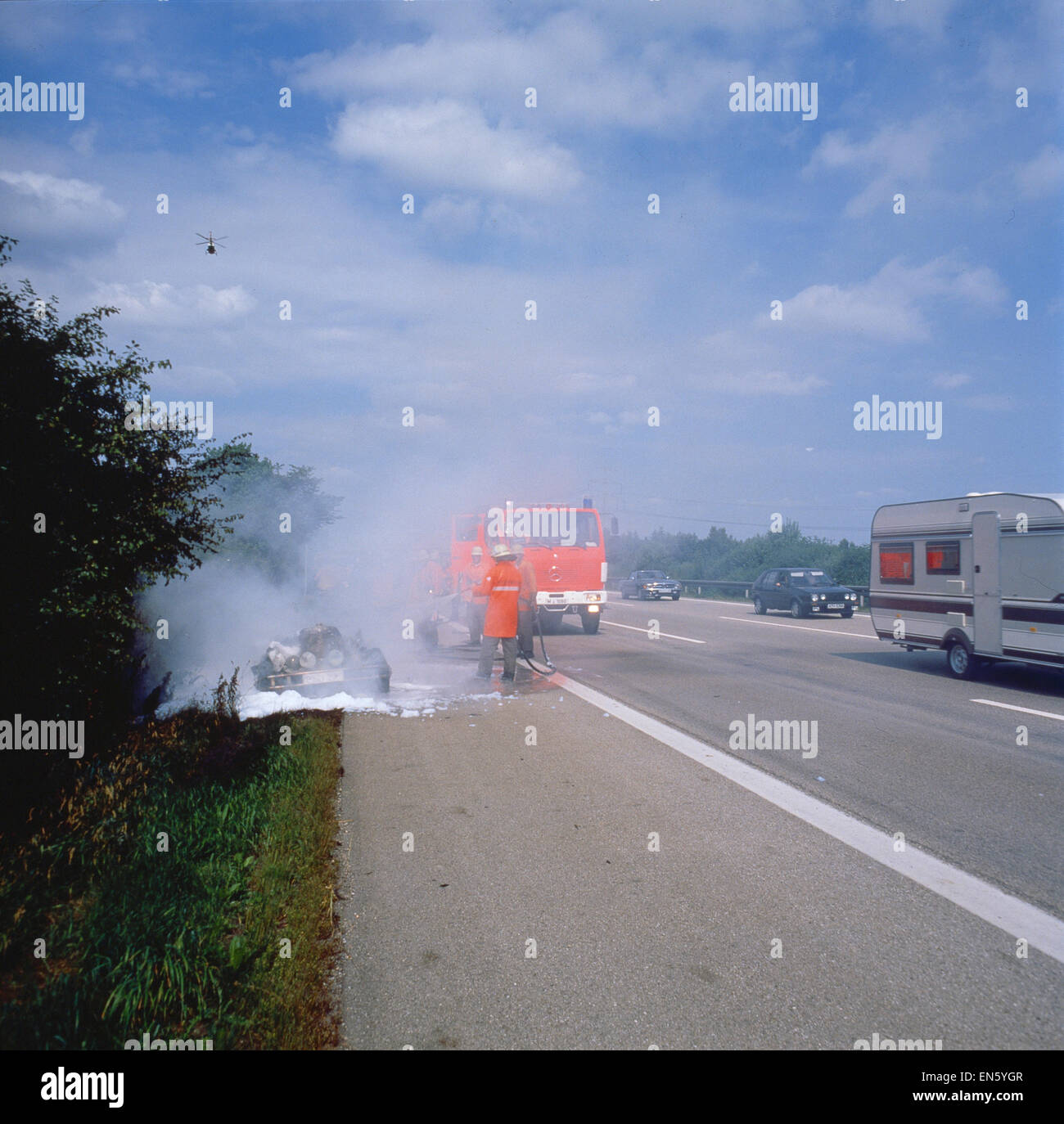 Fire-brigade putting out a burning car on the highway Stock Photo - Alamy