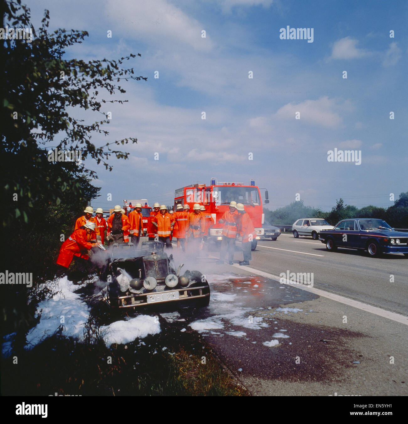 Fire-brigade putting out a burning car on a highway Stock Photo - Alamy