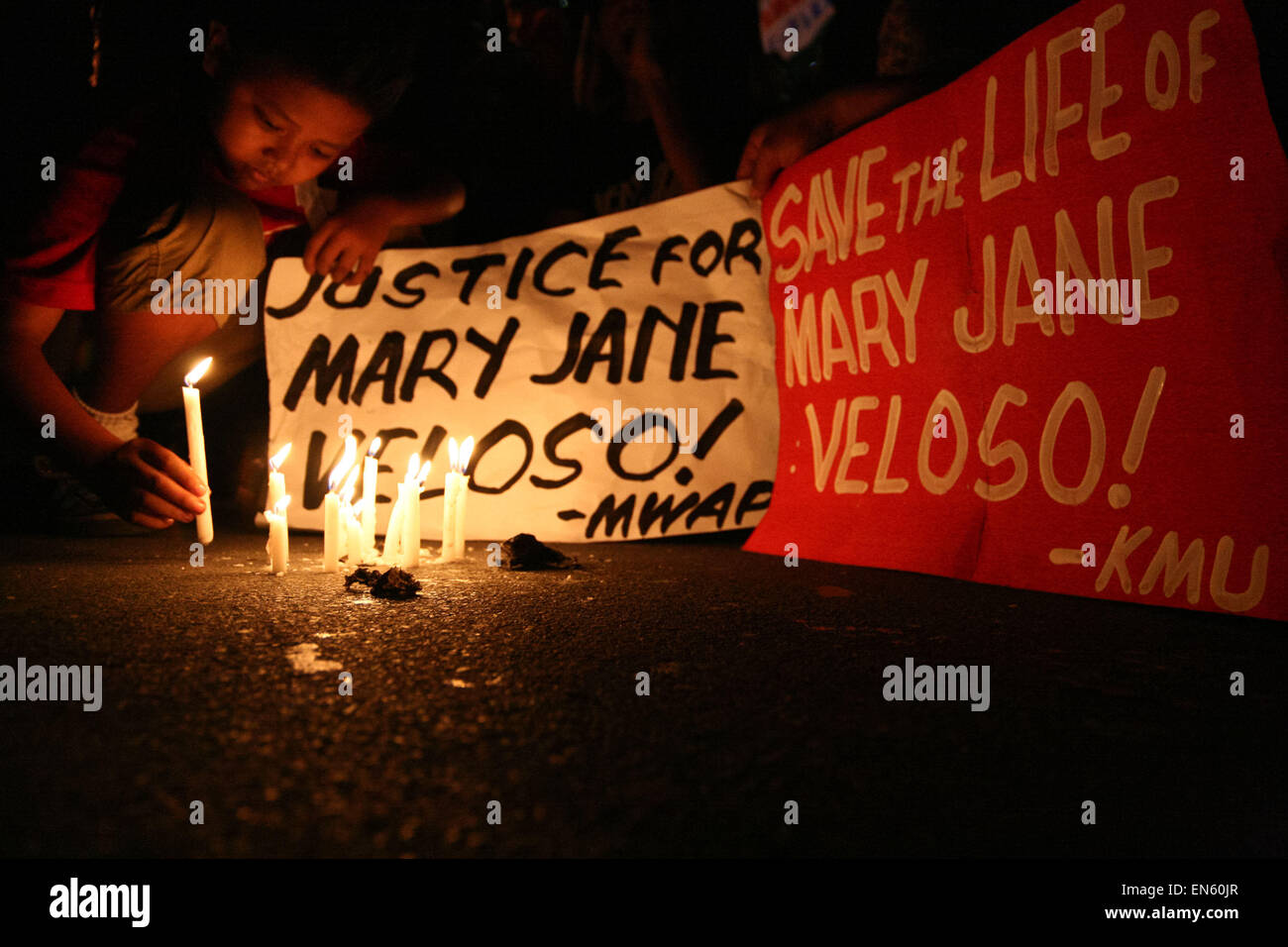 Makati, Philippines. 28th Apr, 2015. A young kid light up candles in ...