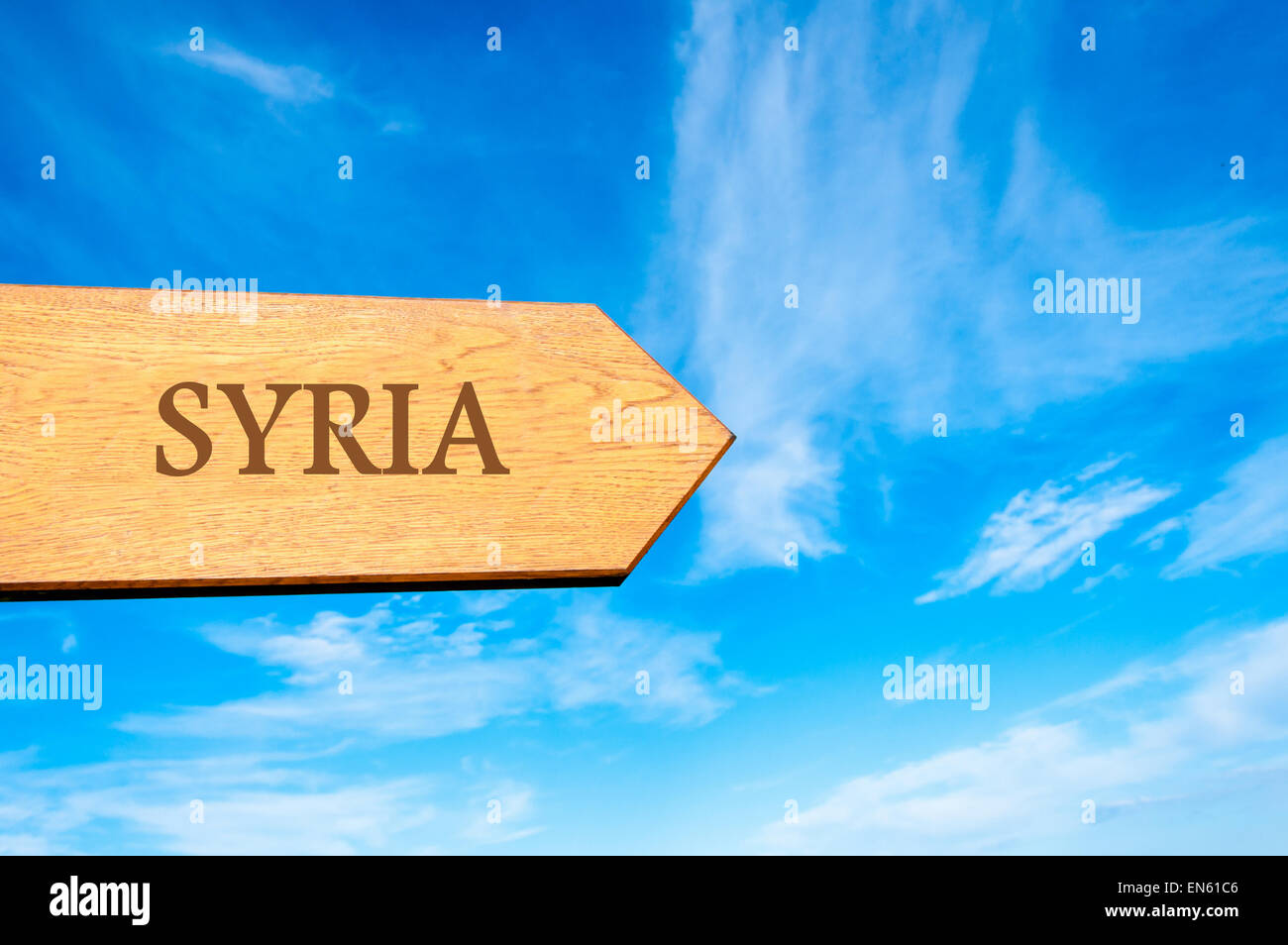 Wooden arrow sign pointing destination SYRIA against clear blue sky ...