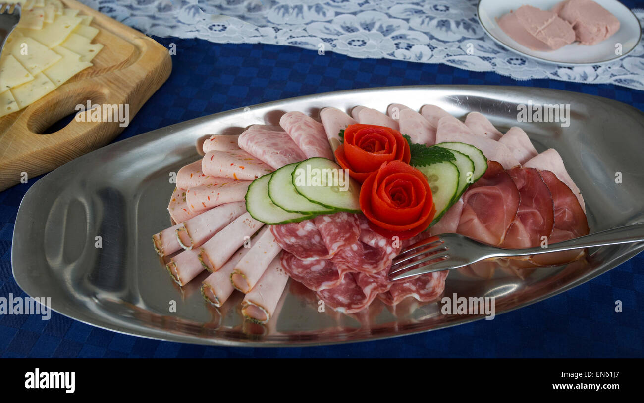 Luncheon table with platters of cold cuts, vegetables and other ...