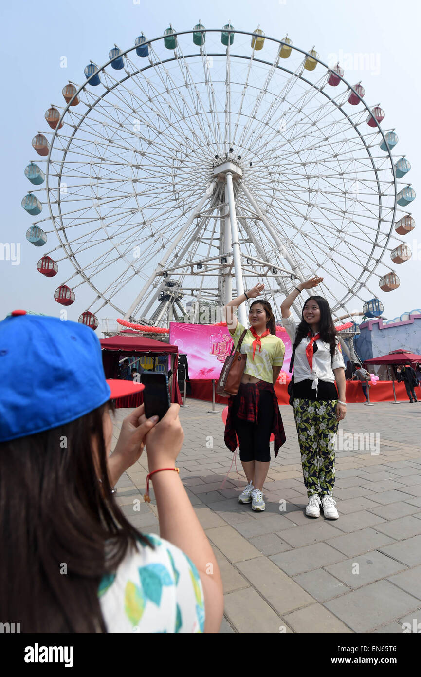 Beijing, China. 29th Apr, 2015. Visitors pose for a photo with a ferris ...