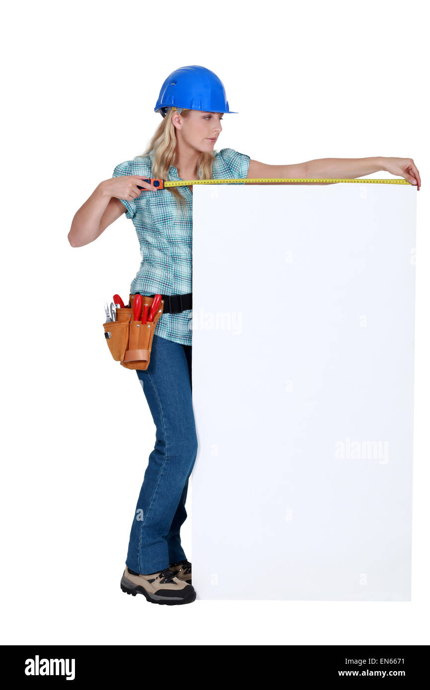 Construction worker measuring a blank board Stock Photo - Alamy