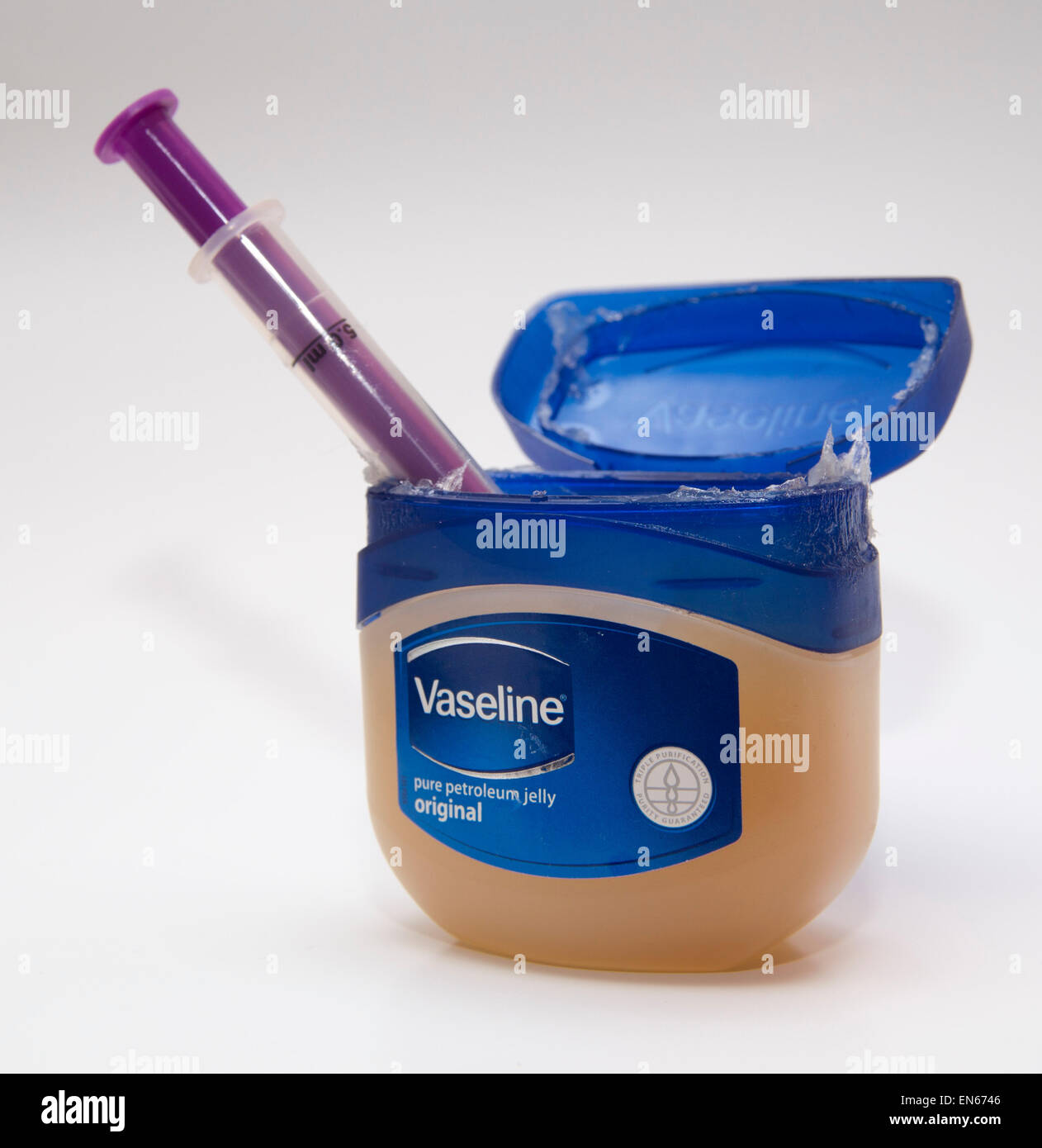 tub of Vaseline petroleum jelly containing a syringe, isolated on white ...