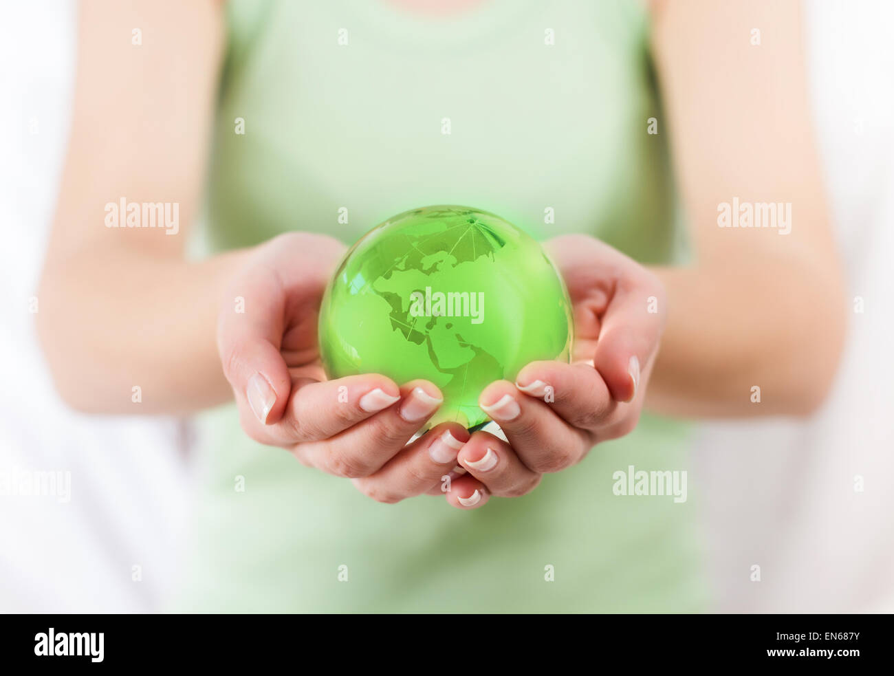 Green Earth Globe Protected by human hands. Glass globe in female hand ...
