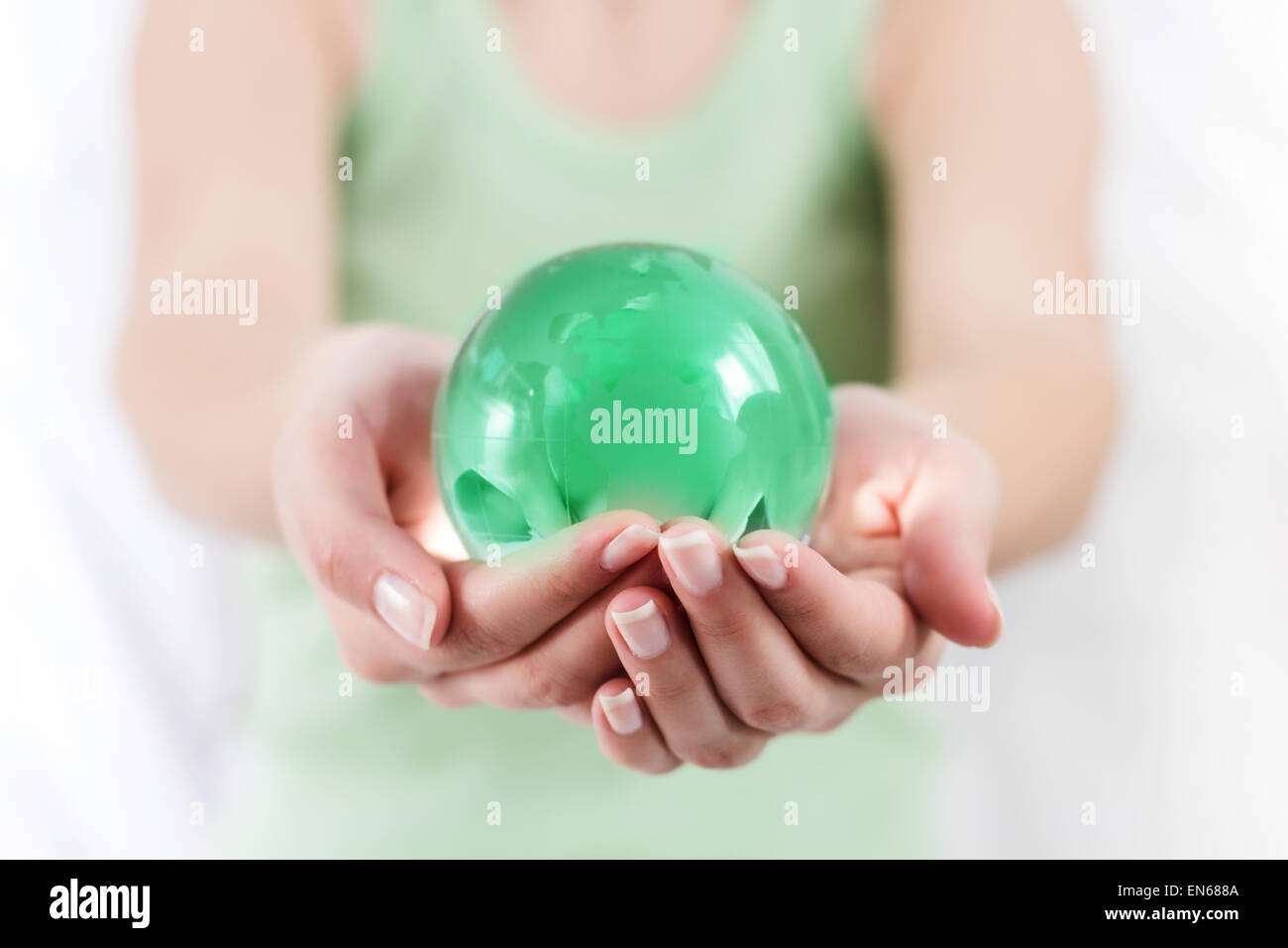 Green Earth Globe Protected by human hands. Glass globe in female hand ...