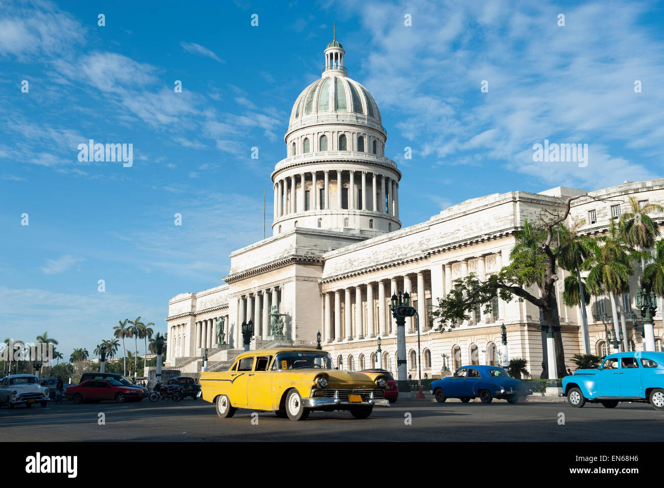 Colorful classic American cars pass in front of the Capitolio building ...