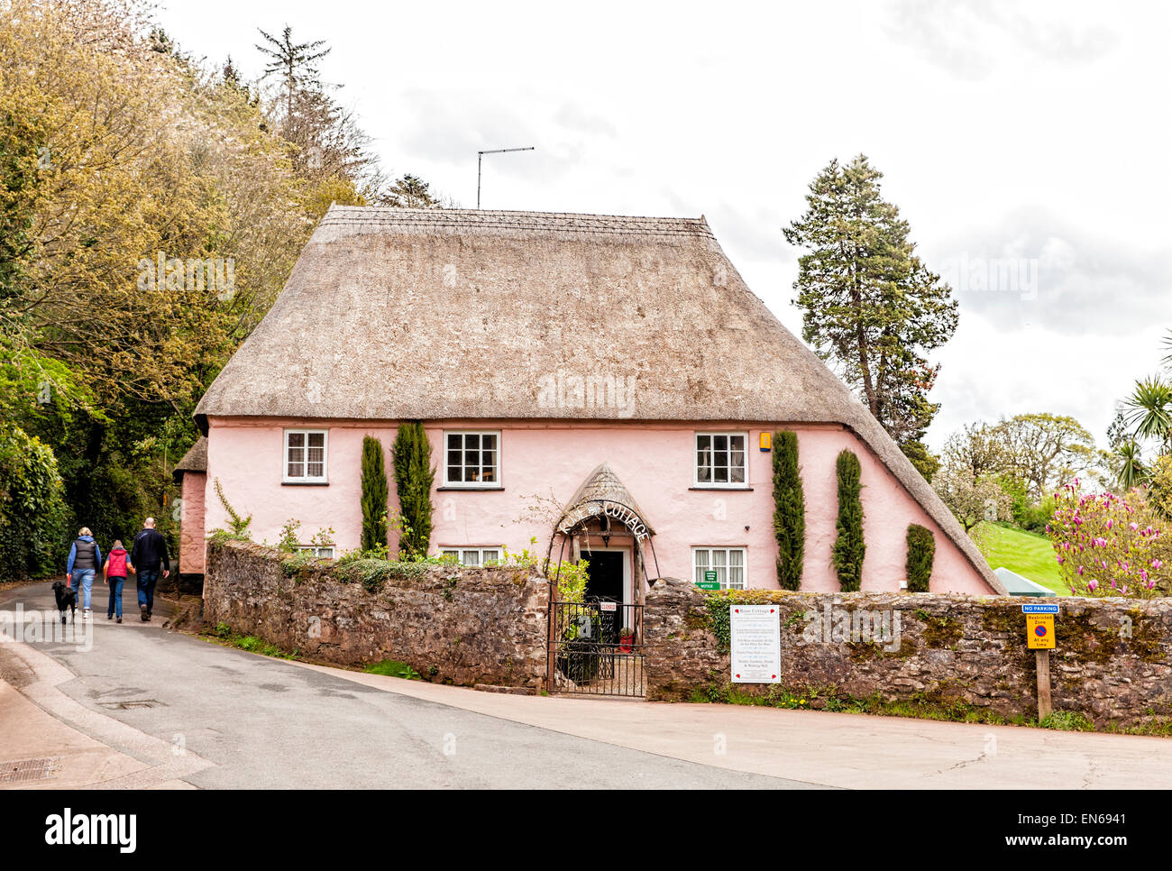 Charming photo of a thatched cottage in Devon with 3 people and their ...