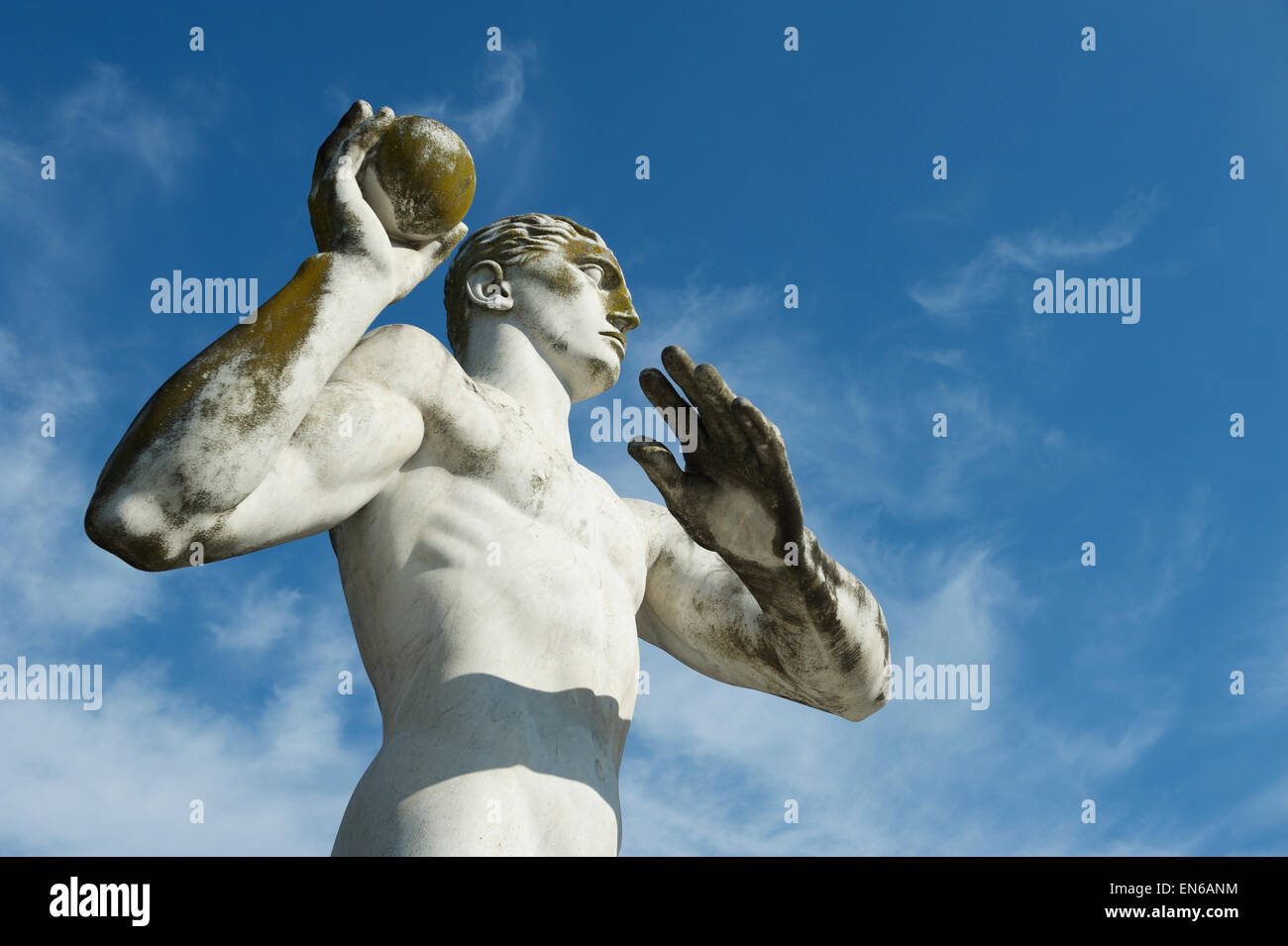 Ancient marble statue of muscular athlete shot put thrower throwing a ...