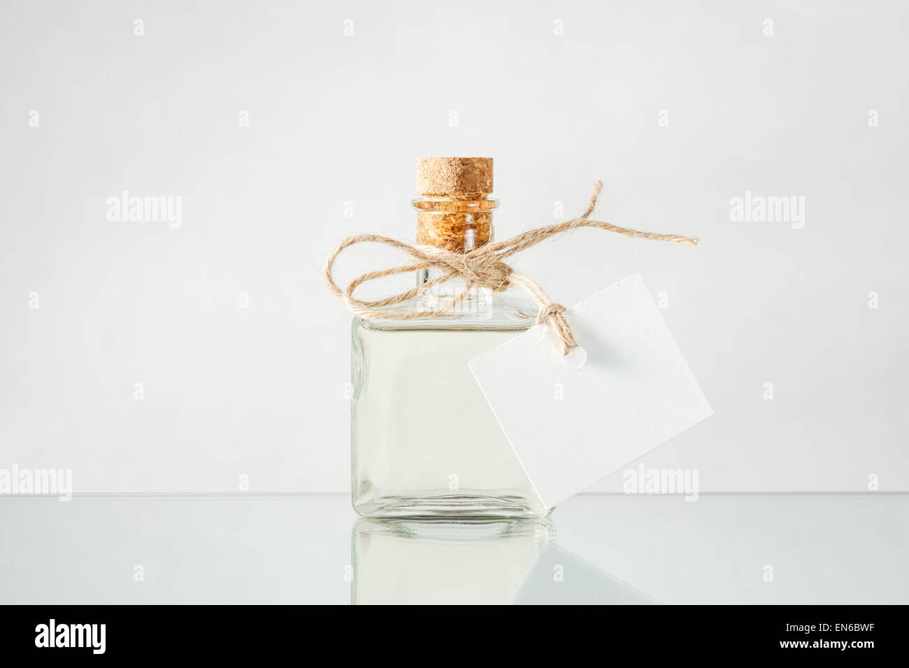Bottle with transparent liquid and empty label on the light background ...