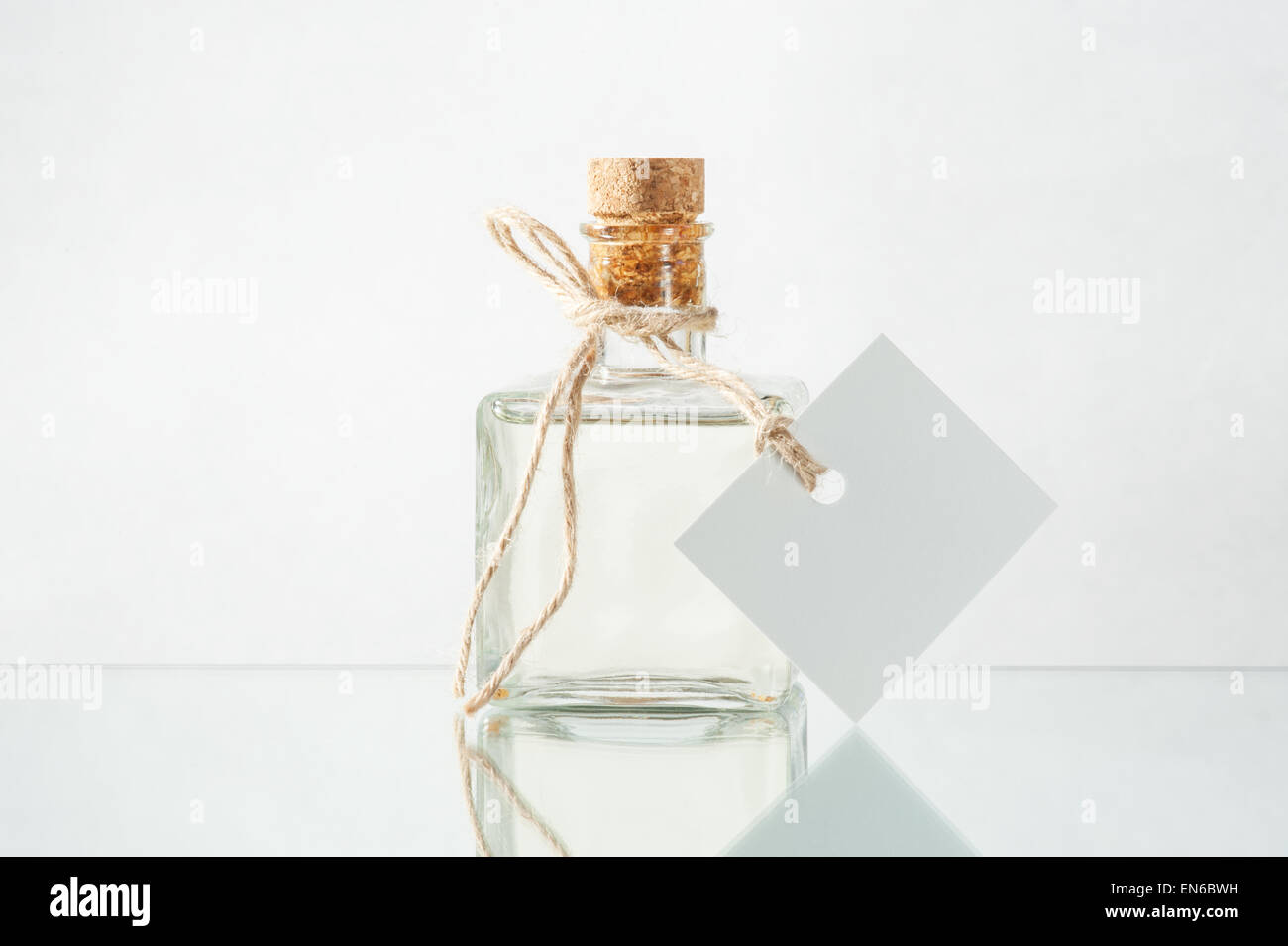 Bottle with transparent liquid and empty label on the light background ...