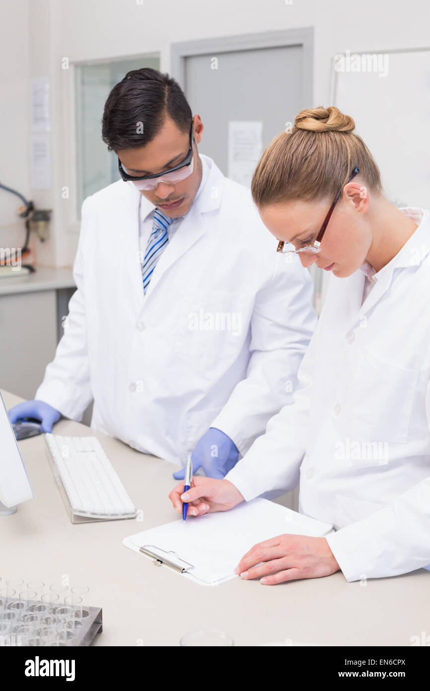 Scientists writing on clipboard Stock Photo - Alamy