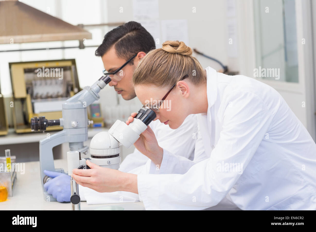 Scientists using microscope Stock Photo - Alamy
