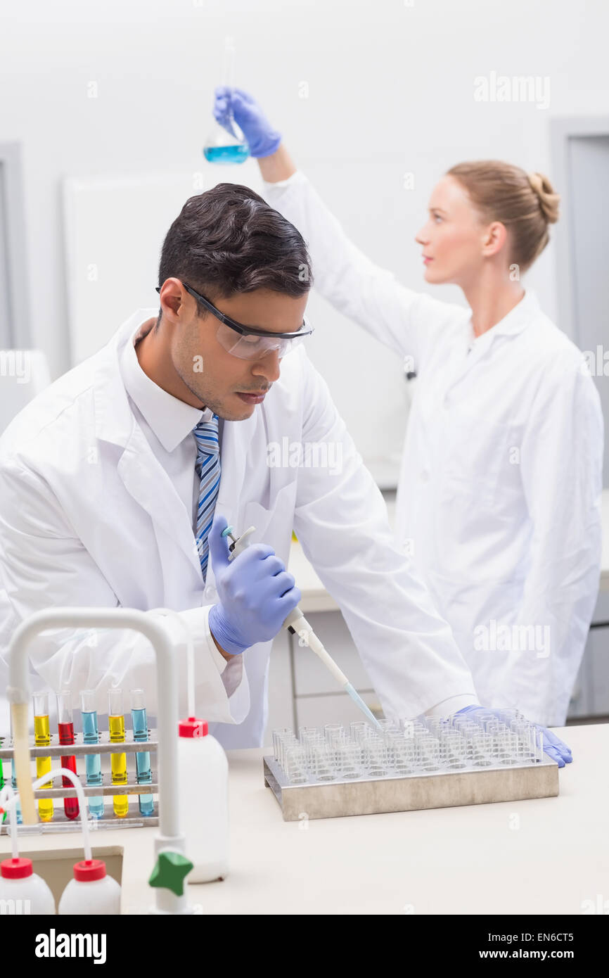 Scientists examining tubes and baker Stock Photo - Alamy