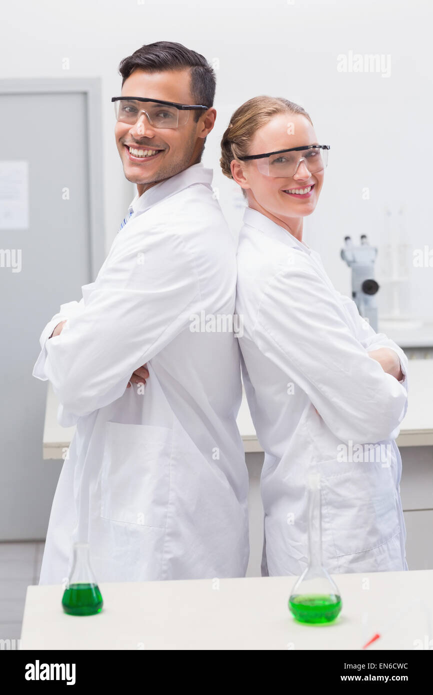Smiling scientists standing back to back Stock Photo - Alamy
