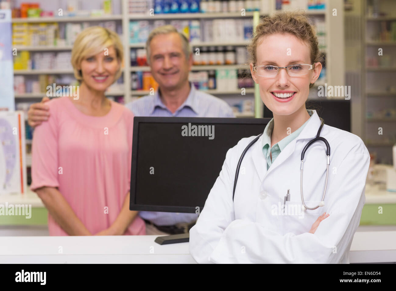 Pharmacist and costumers smiling at camera Stock Photo - Alamy