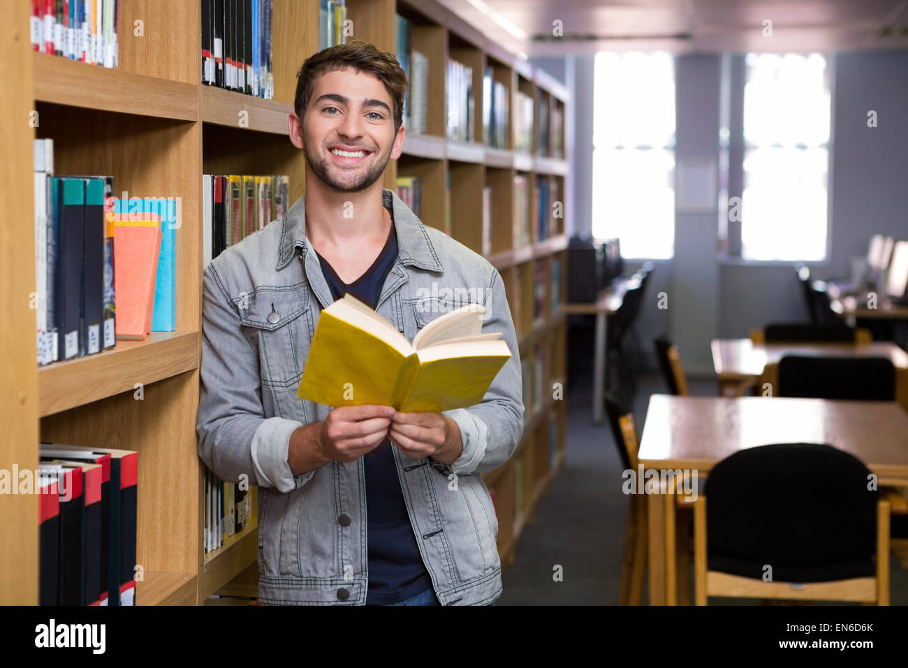Student smiling at camera in library Stock Photo - Alamy