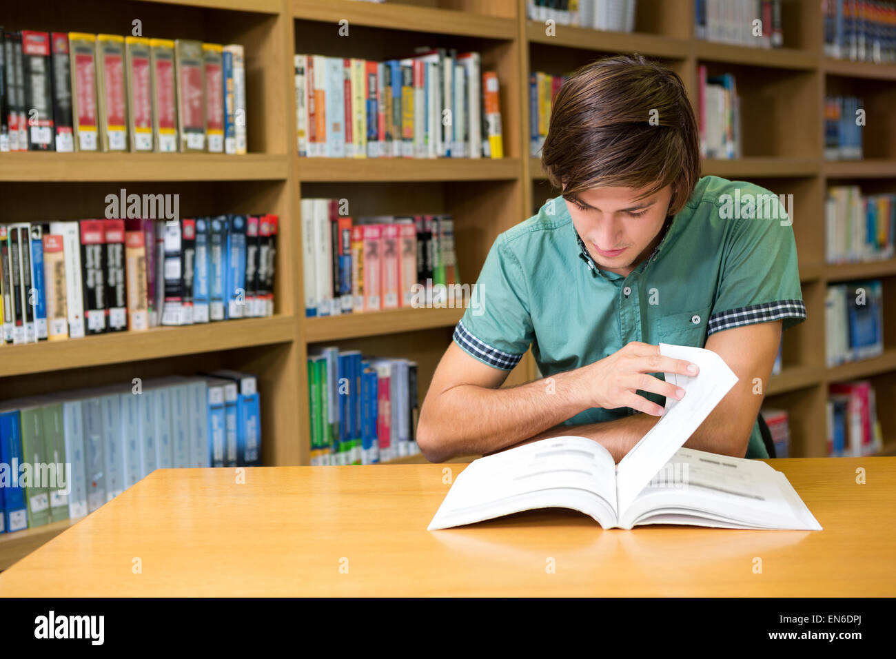 Student sitting in library reading Stock Photo - Alamy
