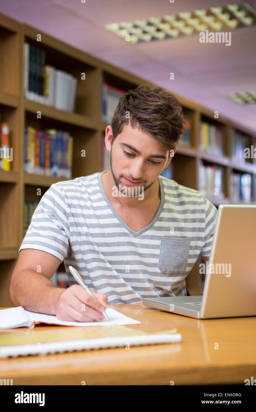 Student studying in the library with laptop Stock Photo - Alamy