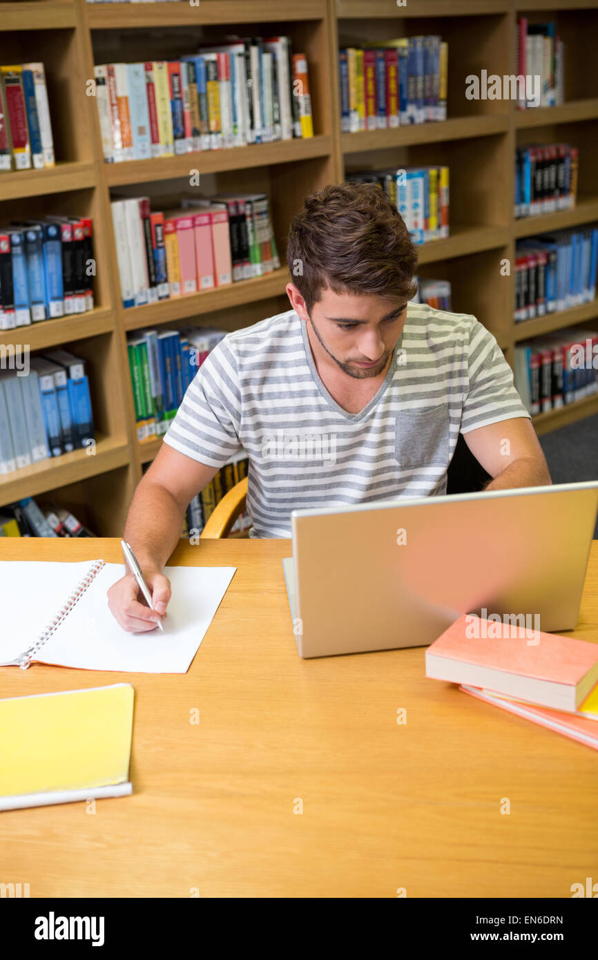 Student studying in the library with laptop Stock Photo - Alamy