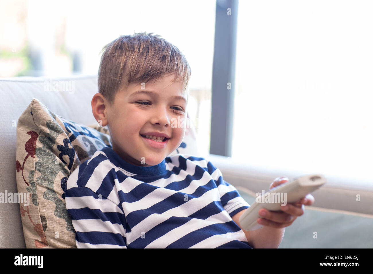 Little boy watching tv on the couch Stock Photo - Alamy