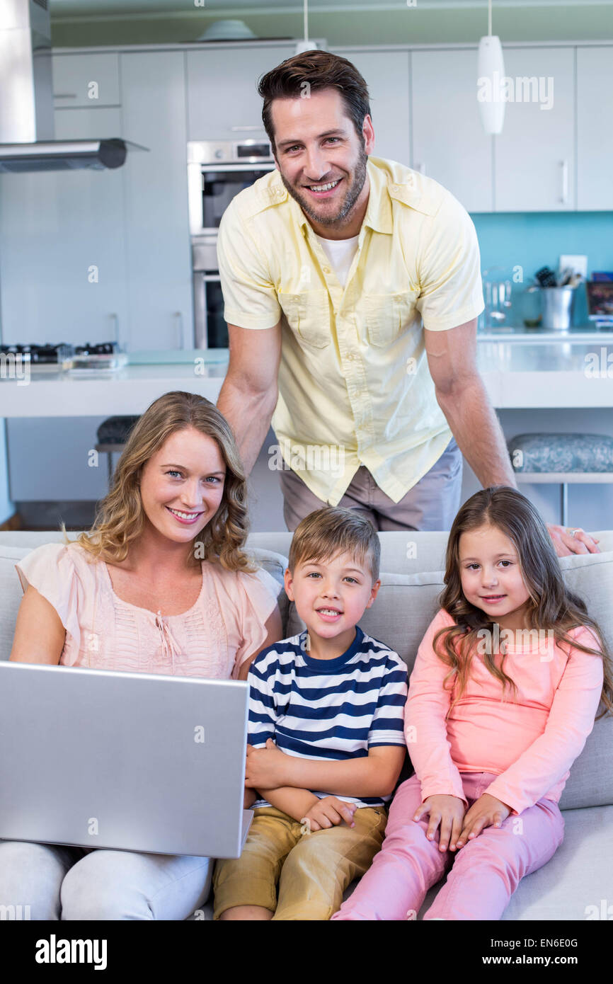 Happy family on the couch together using laptop Stock Photo - Alamy