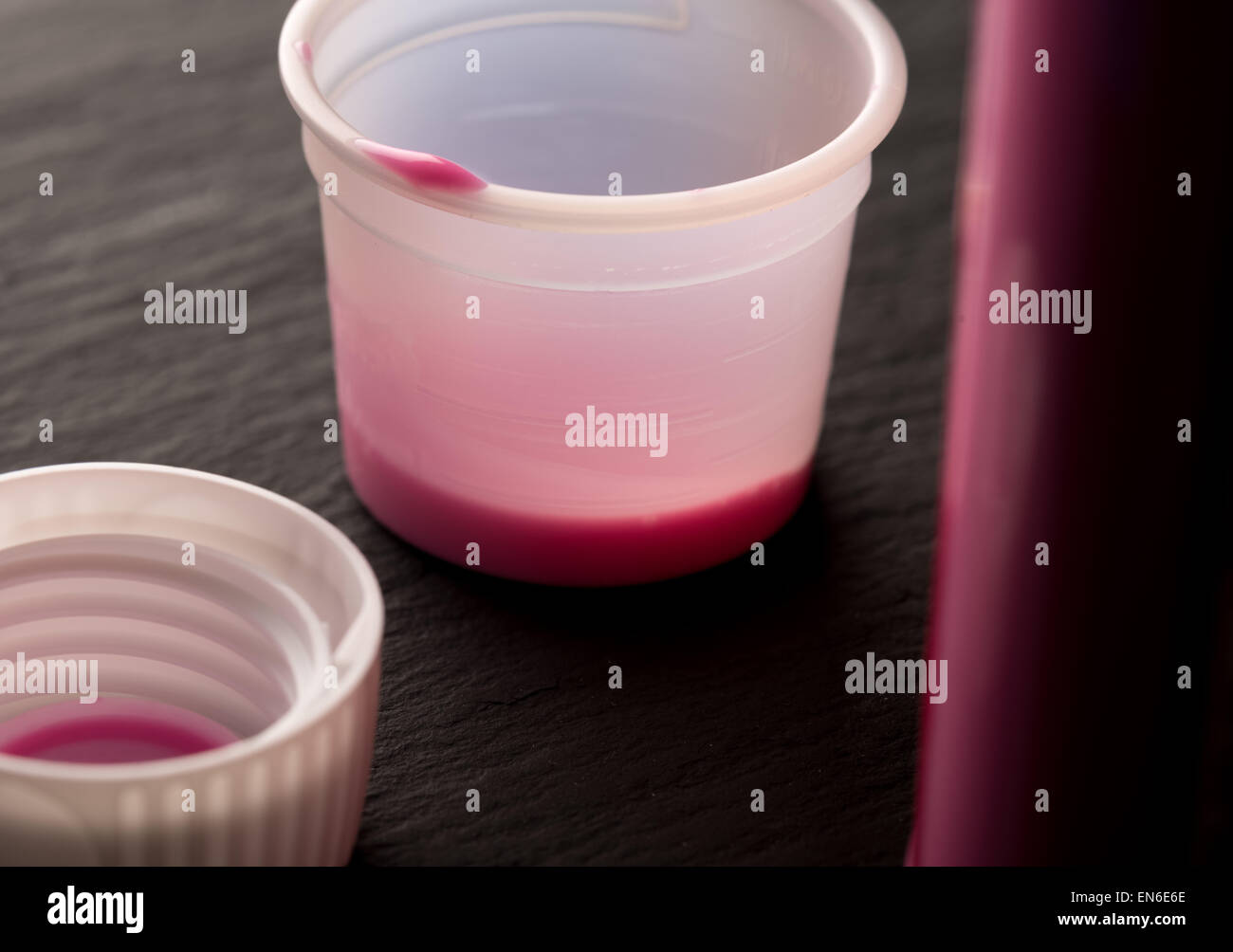 Pink stomach medicine in cup Stock Photo - Alamy